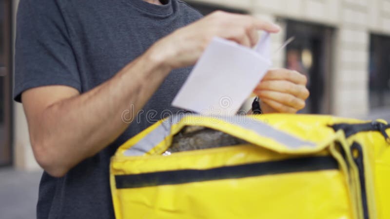 Courier with Backpack Look Inside for Details on Order Receipt, Closeup ...