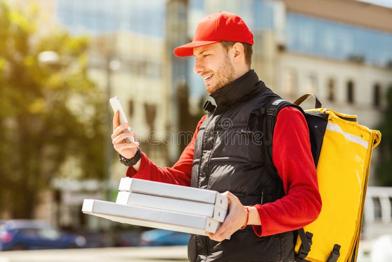 Courier Guy with Pizza Boxes Using Cellphone Walking in City Stock ...