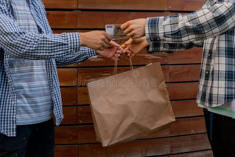 Courier with Paper Bag Giving a Package Delivery To the Customers Stock ...