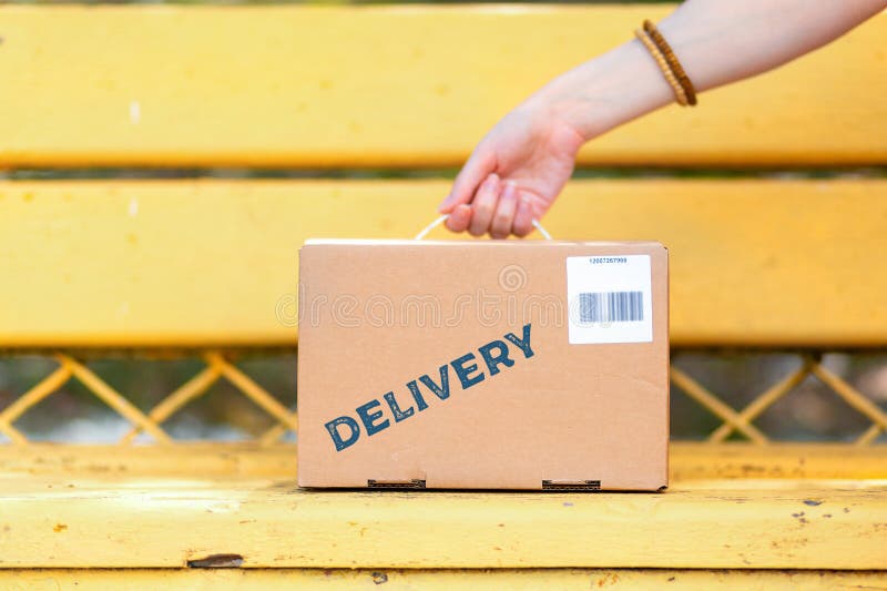 The Courier Puts a Cardboard Box with a Barcode on the Bench. Hand and ...