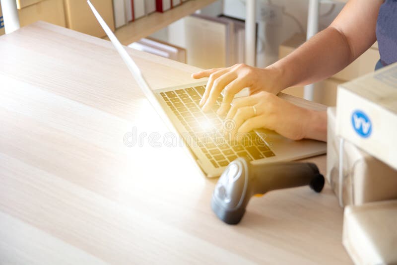Courier Scanning Cardboard Box with Barcode Scanner in Warehouse. Close ...