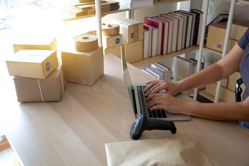 Courier Scanning Cardboard Box with Barcode Scanner in Warehouse. Close ...