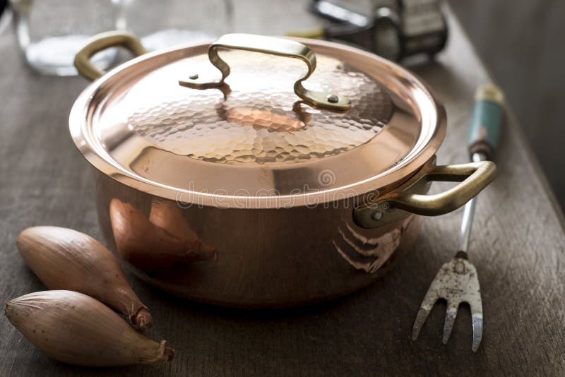 Covered Copper Cooking Pot between Onions and Carving Fork Stock Image ...