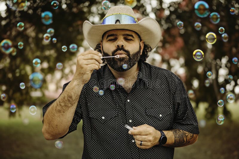 Cowboy Blowing Bubbles in a Park Stock Photo - Image of traditional ...