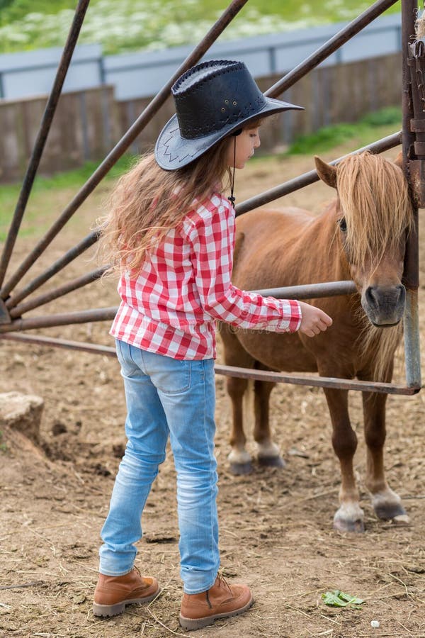 Cowboy girl with a pony stock photo. Image of foal, checkered - 315408250