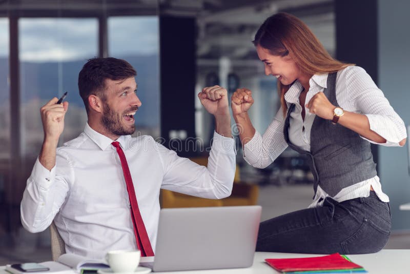 Coworkers Celebrating Success in Modern Office Using Laptop Computer ...