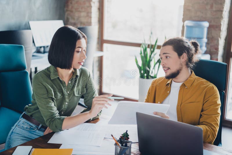 Coworkers Collaborating at a Desk in a Bright Office Setting with ...