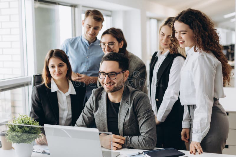 Coworkers Looking at a Computer and Talking about Work Stock Image ...
