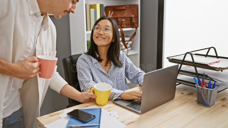 Coworkers Share a Light Moment with Coffee in a Modern Office Setting ...