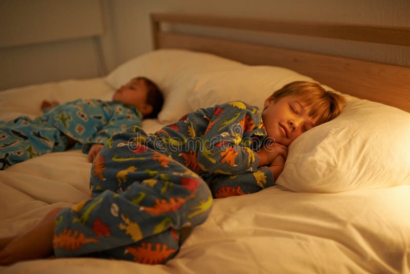 Cozy and Comfortable. Two Little Boys Sleeping on a Bed with the Light ...