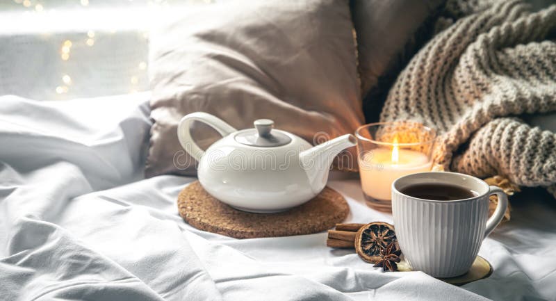 Cozy Composition with a Cup of Tea, a Teapot and a Candle in the Bed ...