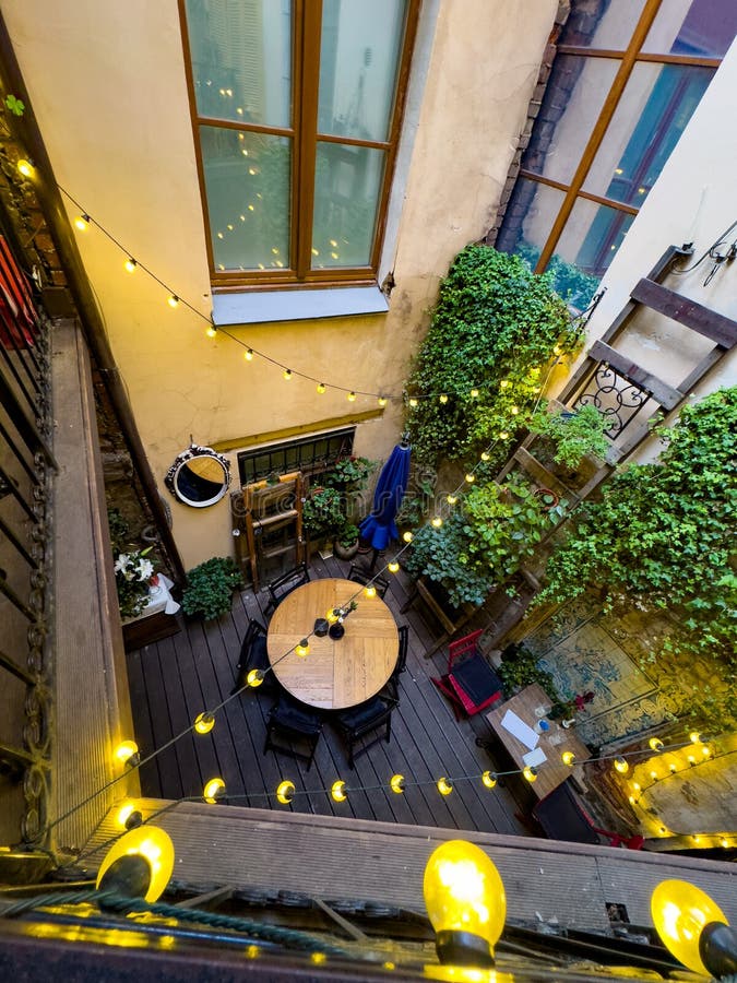 Cozy Courtyard Cafe with String Lights and Greenery Stock Image - Image ...