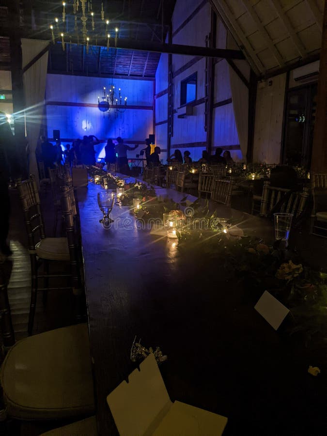Cozy Evening Reception in Rustic Barn Setting with Candles and People ...