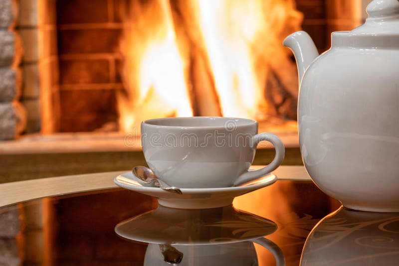 Cozy Fireplace Scene, White Cup of Tea and Teapot on a Table Stock ...