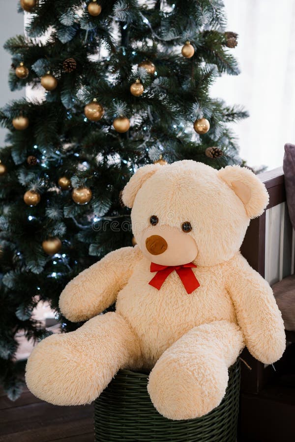 Cozy Holiday Scene Featuring a Plush Teddy Bear beside a Christmas Tree ...