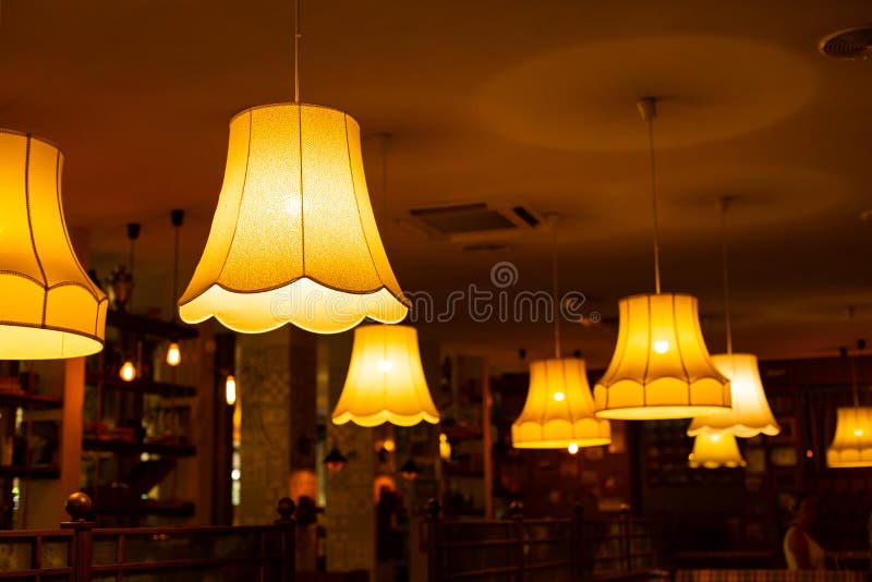 The Cozy Interior of the Cafe. Warm Yellow Light Chandeliers and ...