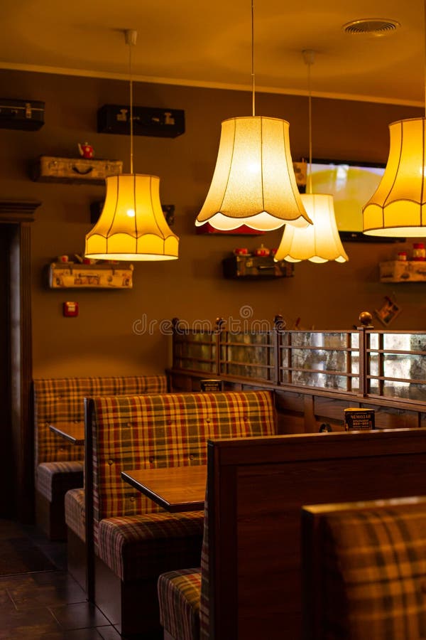 The Cozy Interior of the Cafe. Warm Yellow Light Chandeliers and ...