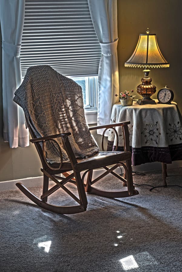 Cozy Interior with Rocking Chair and Lamp-lit Table. Editorial Stock ...