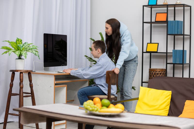 A Woman is Assisting a Boy with a Computer in Their Cozy and Inviting ...