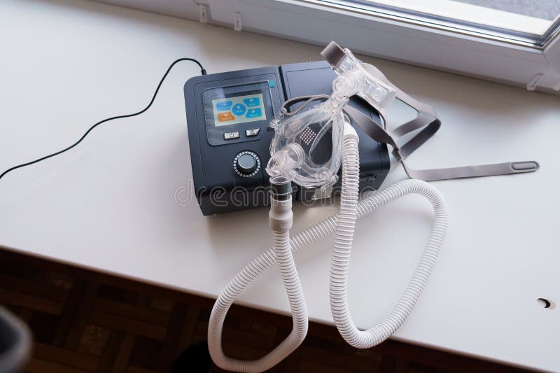 CPAP Machine for Sleep Apnea Treatment with Hose and Mask on a Table ...