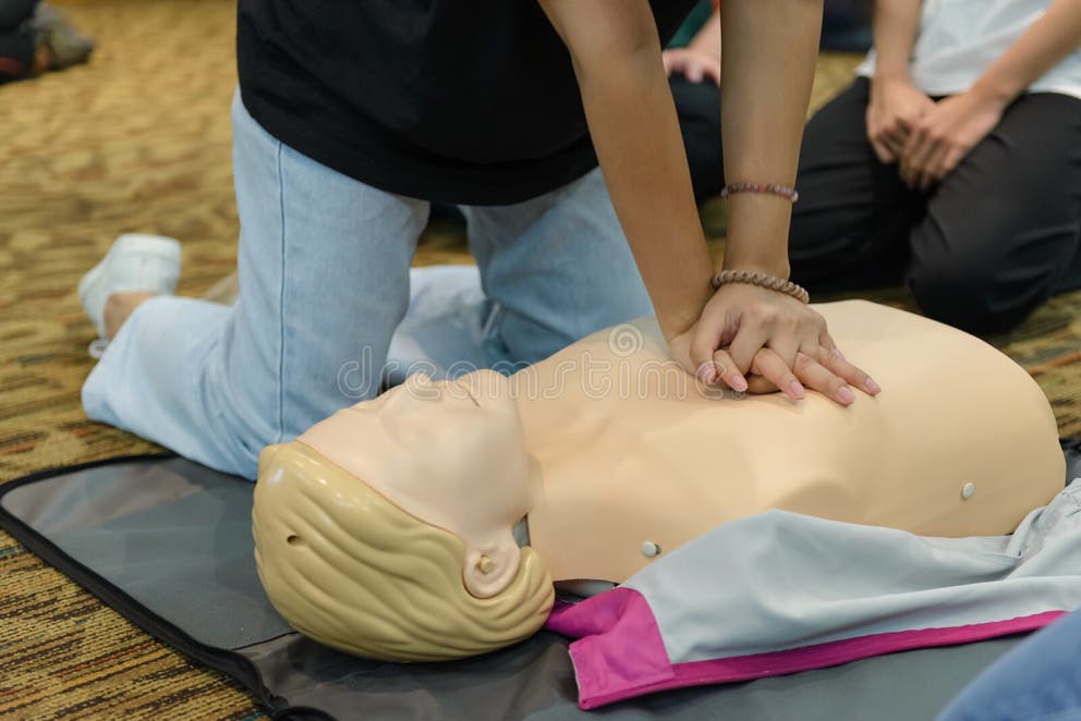 CPR First Aid Training with CPR Dummy in the Class. Demonstrating Chest ...