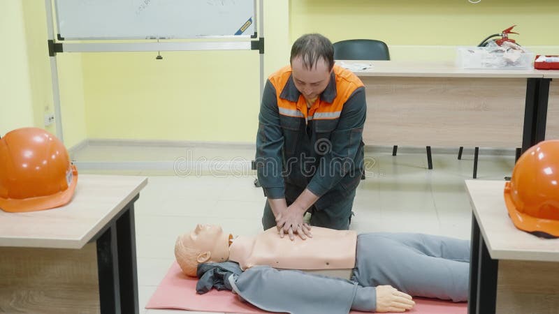 CPR Training Session with Worker Performing Chest Compressions on a ...