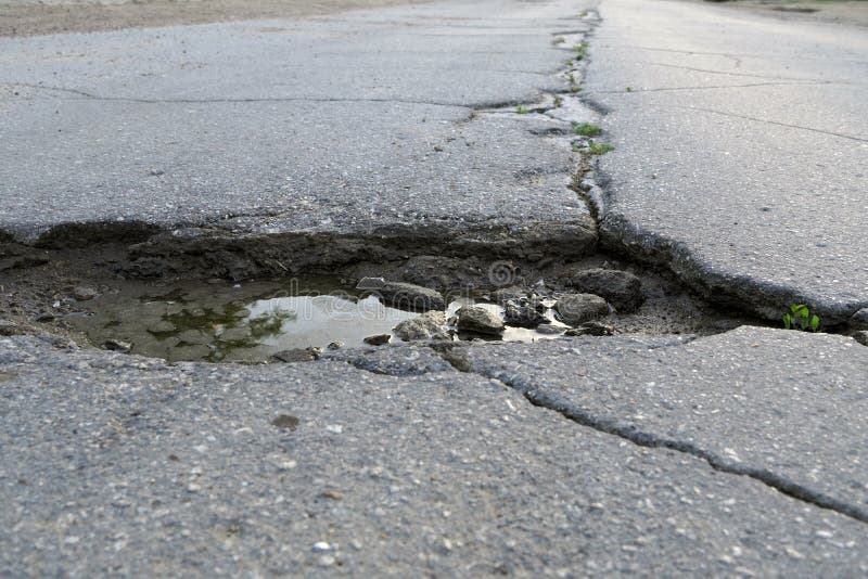 Crack in the Asphalt of the Road and a Puddle Stock Photo - Image of ...