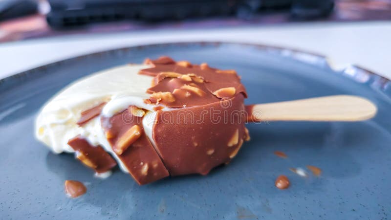 A Cracked and Bitten Ice Cream with Almonds and Chocolate Coating on a ...