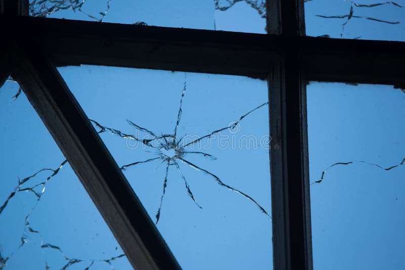 Cracked and Broken Window Glass Punched by a Pistol Bullet Stock Image ...