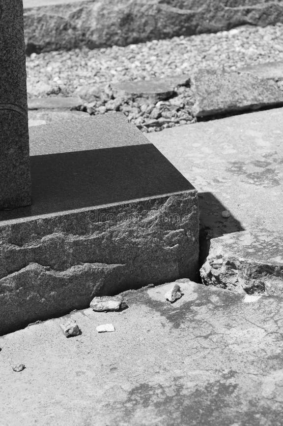 Cracked Cement at Base Corner of Rough Hewn Dark Gray Granite Tombstone ...