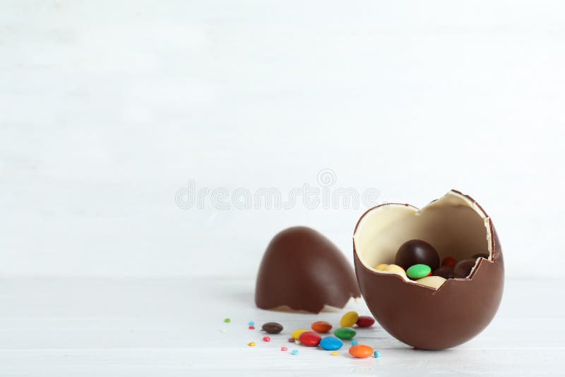 Cracked Chocolate Easter Egg with Candies on Table. Stock Image - Image ...