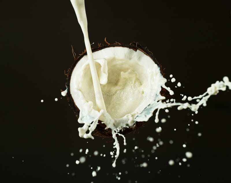 Cracked Coconut with Milk Splash Flying in the Air, Isolated on Black ...