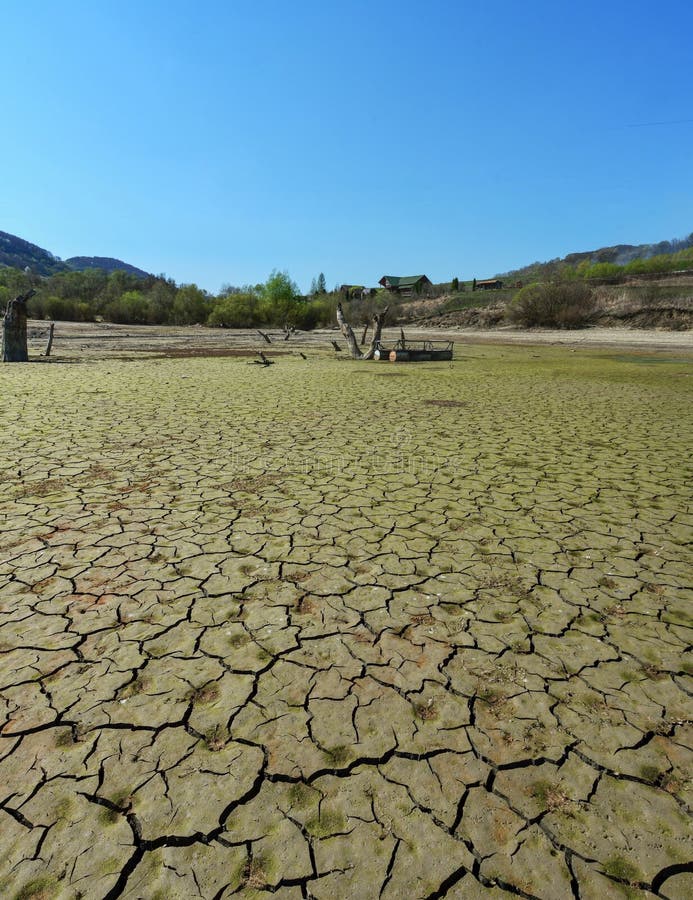 Cracked Mud on the Bottom of a Dried Lake with Forested Hills and the ...