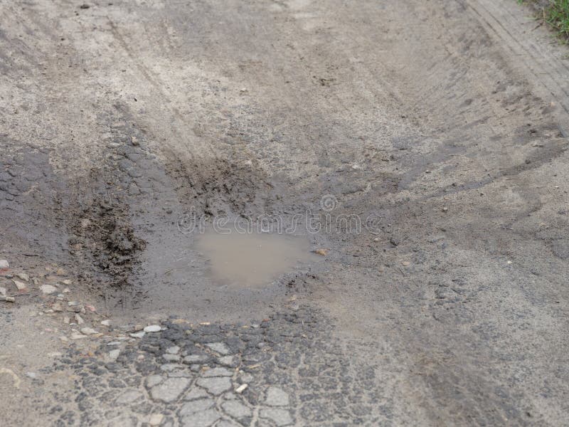 Cracked Road with a Muddy Puddle in it Stock Photo - Image of road ...