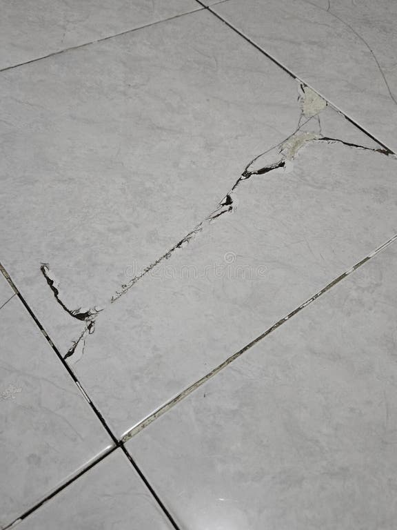 Cracked tile on the floor. stock image. Image of building - 329917999