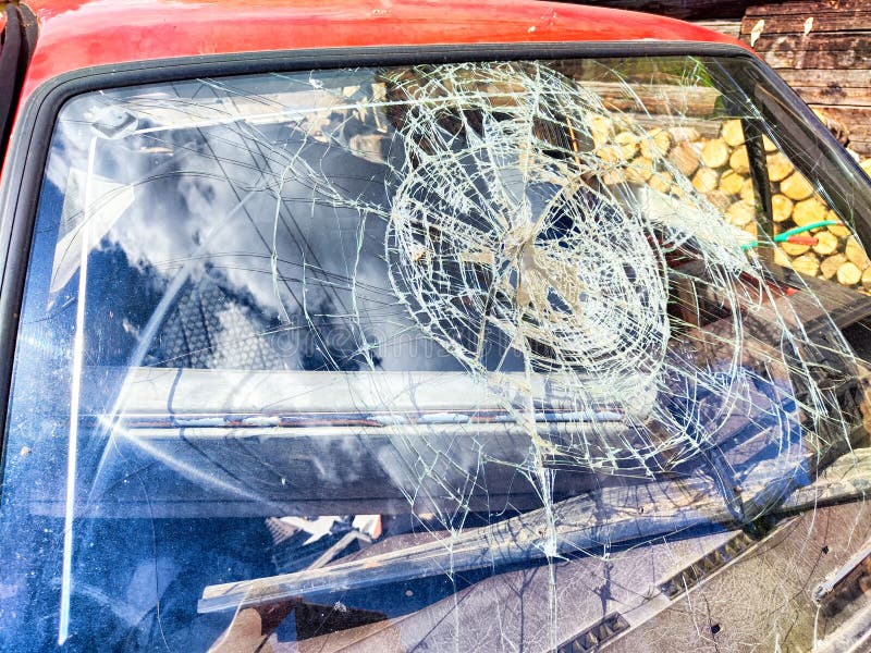 A Cracked Windshield Reveals Extensive Damage on a Parked Vehicle ...