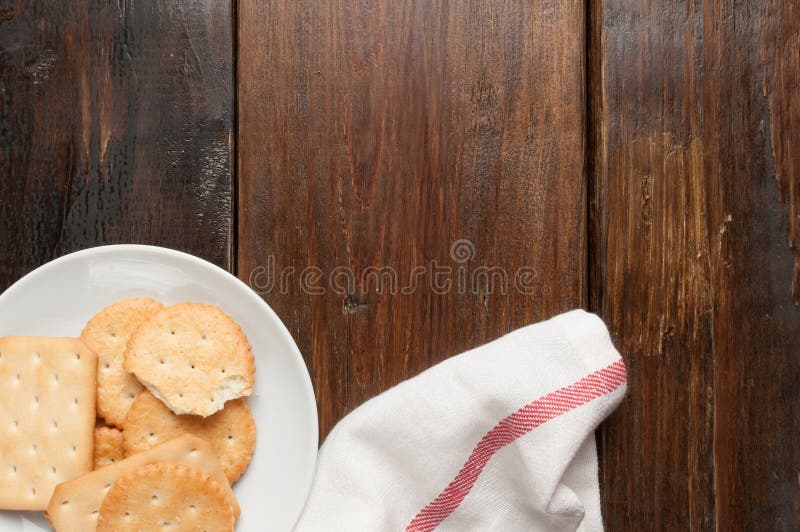 Cracker in White Plate and Fabric Over Wood Table Stock Image - Image ...