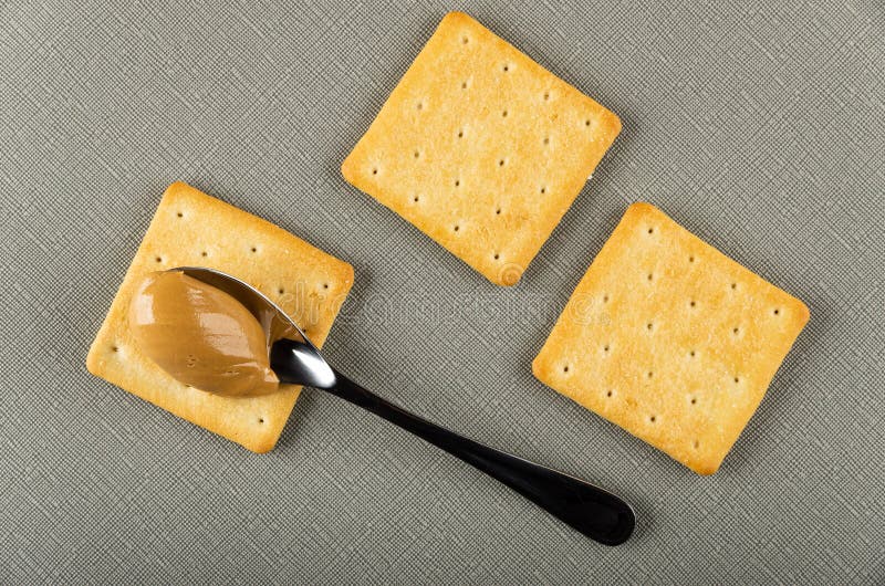 Crackers, Spoon with Peanut Butter on Cookie on Table. Top View Stock ...