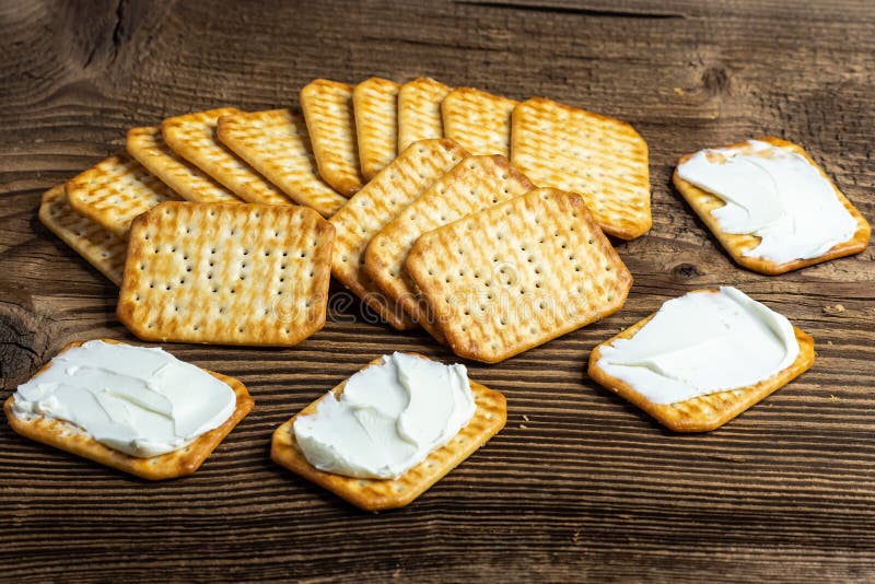 Crackers Spread with Cheese As a Light Snack on a Wooden Plank Stock ...