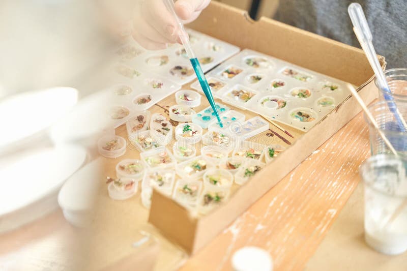 Crafting Jewelry: Mixing Resin and Botanical Elements in Molds for ...
