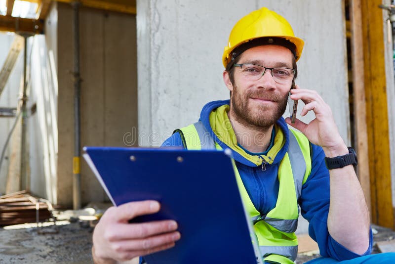 Craftsman on Construction Site during a Phone Call with Checklist Stock ...