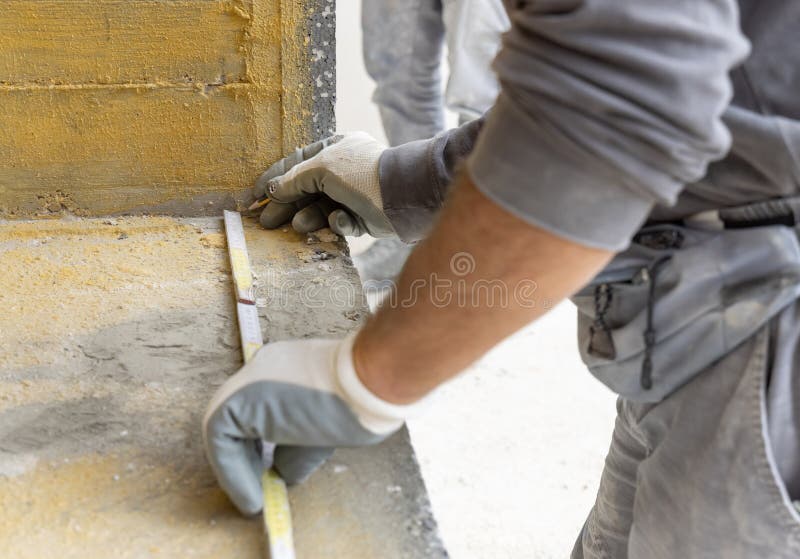 Craftsman in Gloves Measuring a Dirty Surface with Folding Ruler ...