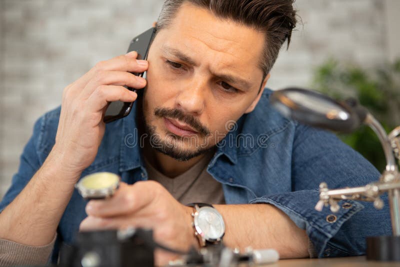 Craftsman Repairing Watch while Talking on Phone Stock Image - Image of ...