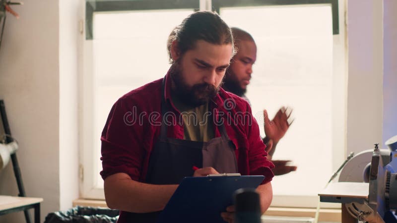 Craftsperson Drawing Blueprints in Studio Next To Coworker Stock ...