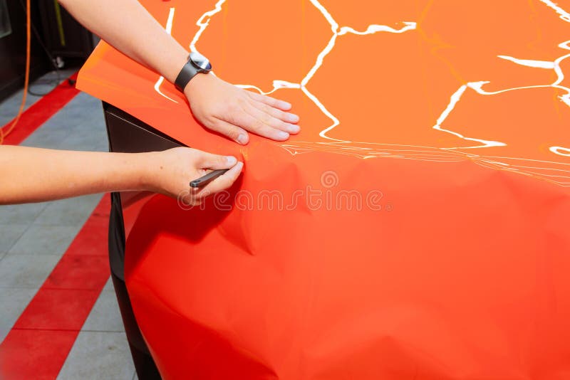 Craftsperson Drawing Intricate Patterns on Bright Orange Material in a ...