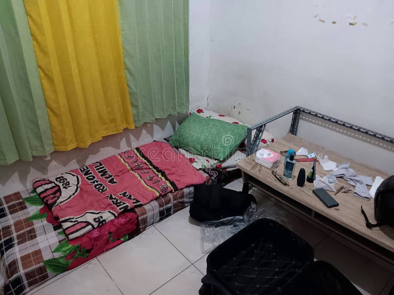 Cramped Room with Bed, Desk, and Personal Items in Dim Lighting Stock ...