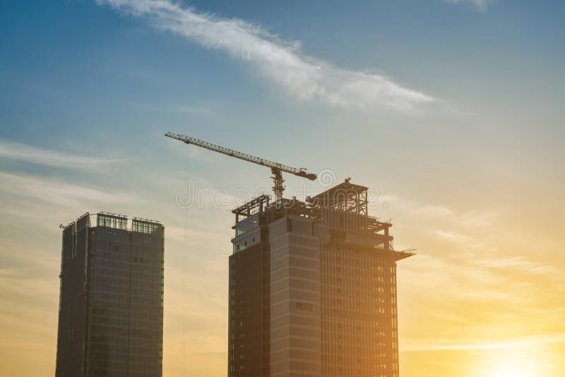 A Crane Building a Skyscraper Against a Sunset. Stock Photo - Image of ...