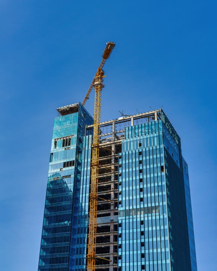 A Crane Building a Skyscraper Against a Blue Sky. Stock Image - Image ...