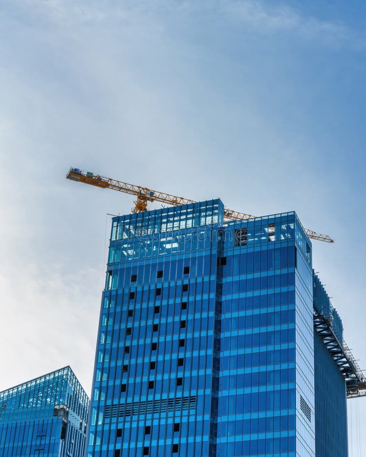 A Crane Building a Skyscraper Against a Blue Sky. Stock Photo - Image ...