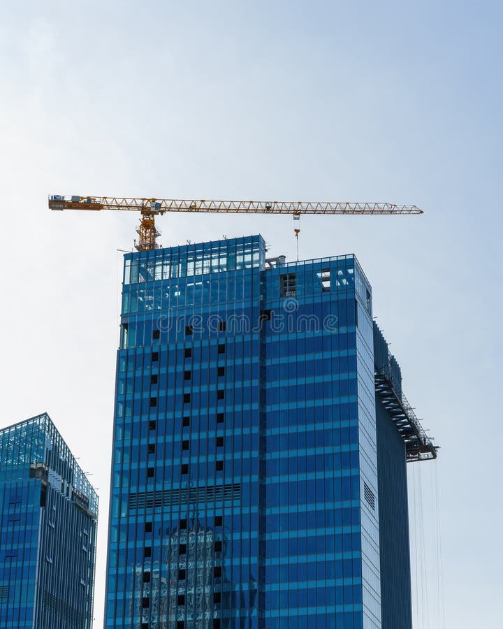 A Crane Building a Skyscraper Against a Blue Sky. Stock Photo - Image ...